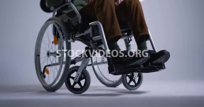Young man in wheelchair looking forward then at camera handicap ...