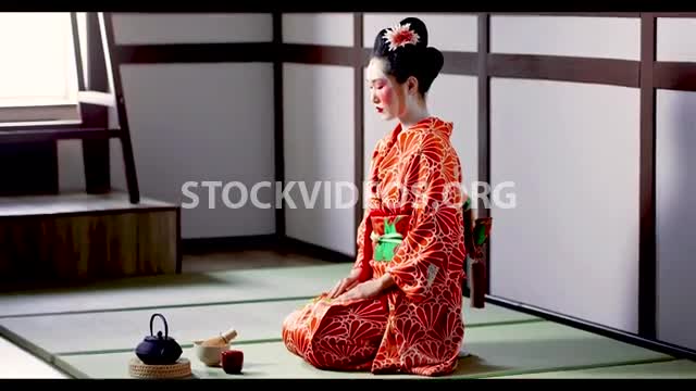 Japanese woman sitting on the floor seiza-style kneeling folding her ...